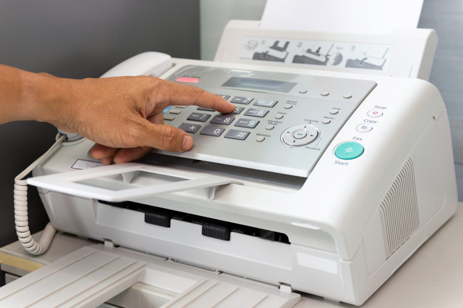 Hand man are using a fax machine in the office | PAAS National