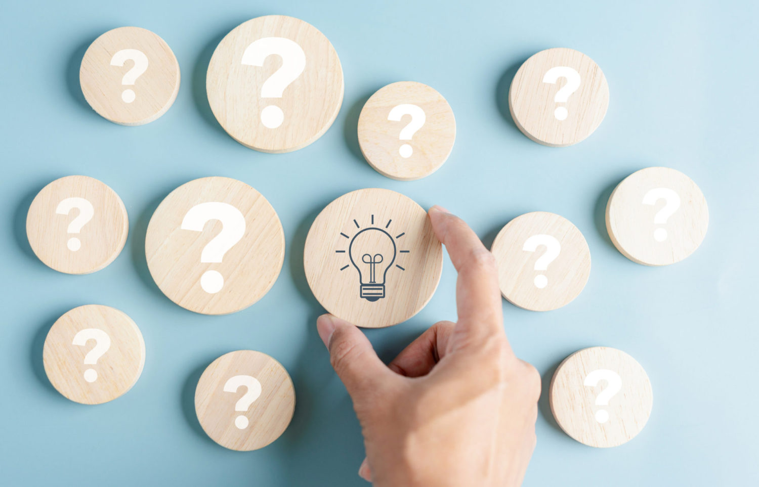 Hand holding Light Bulb which among Question icon. Target solution ...