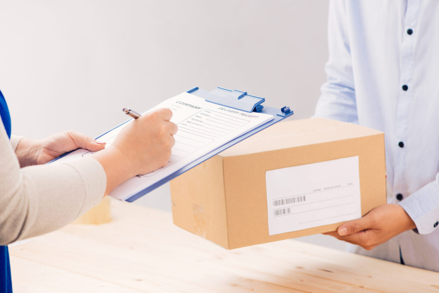 Woman customer signing receipt and receiving the parcel from delivery ...